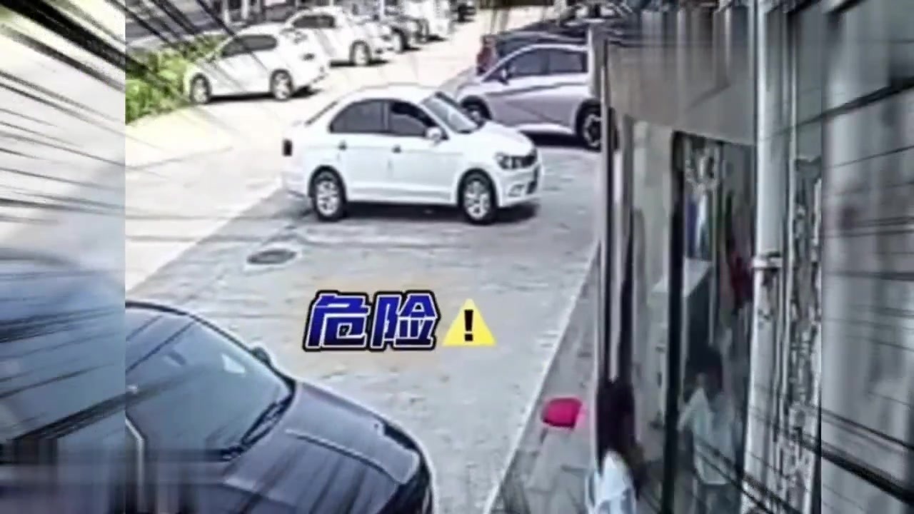 一男童在酒店的玻璃旋转门内玩耍,不慎将脚卡在门的底部
