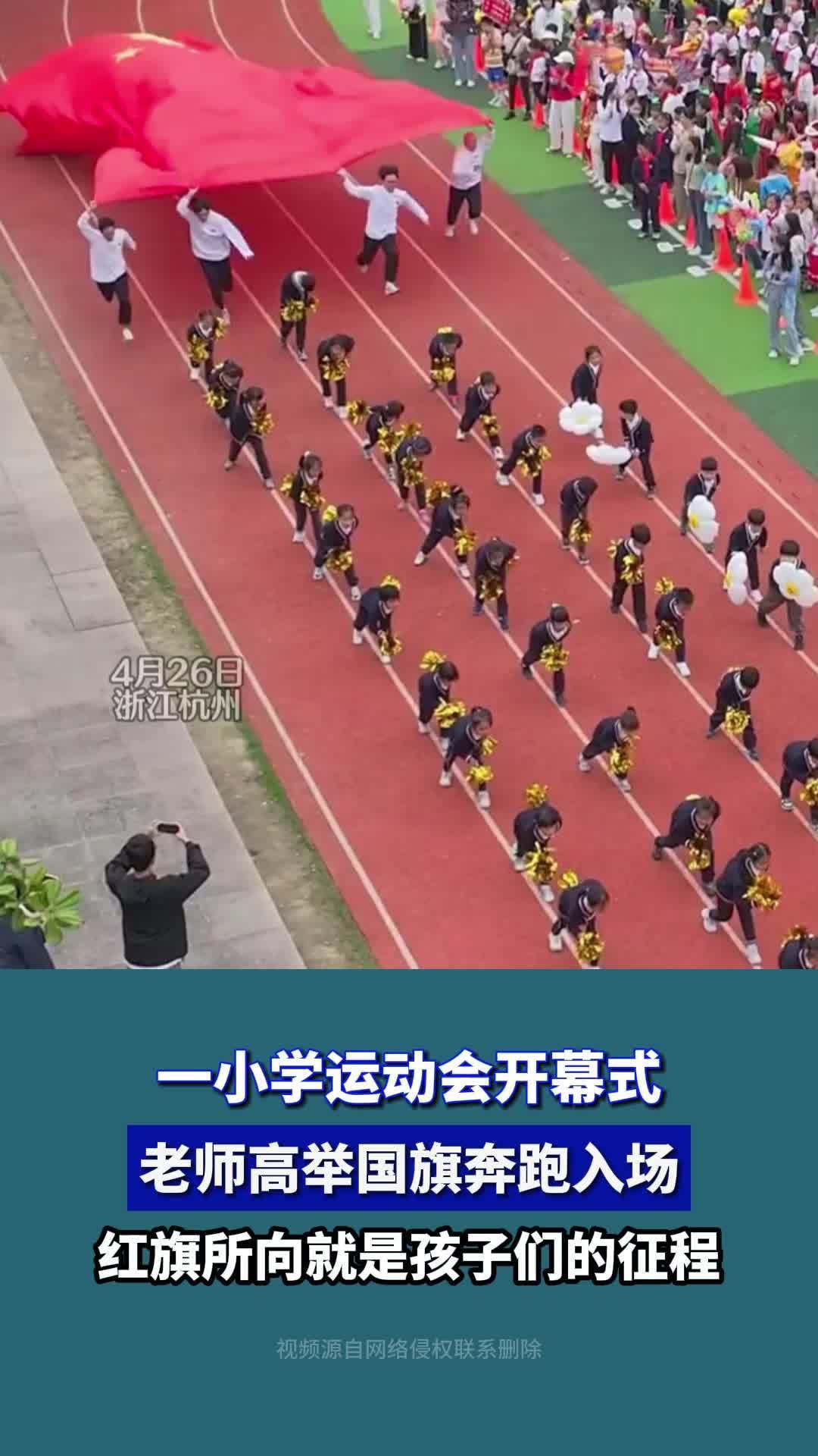 一小学运动会开幕式,老师高举国旗奔跑入场