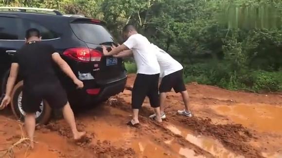 汽车泥泞道路被困上演人工推车。摩托车司机的表现亮了
