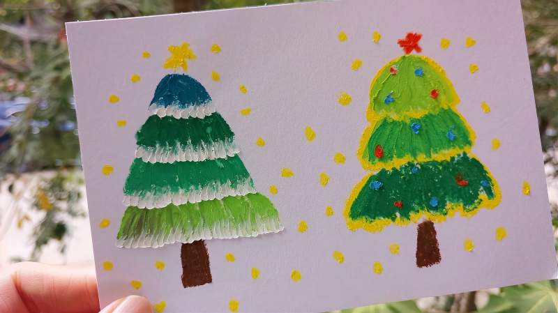 用油画棒画两棵圣诞树,一棵堆满积雪,一棵灯光闪闪,你喜欢吗?