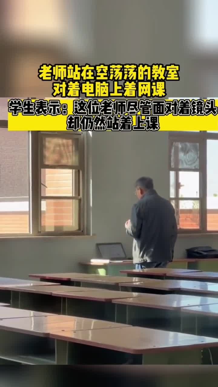 认真的老师独自一人站在教室里对着电脑进行教学