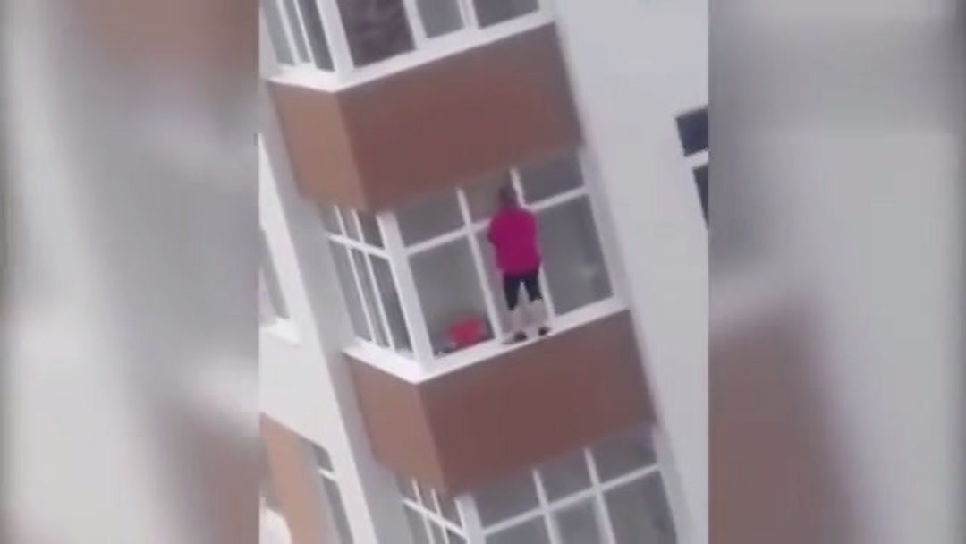 太令人震憾了,红衣女徒手高楼外侧擦窗户玻璃!