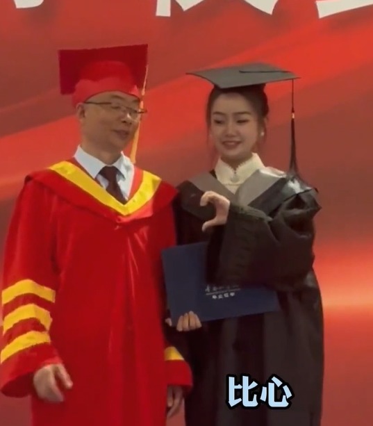 毕业典礼女生与校长合照比心,校长比心不规范,女生上手"掰弯"校长手指