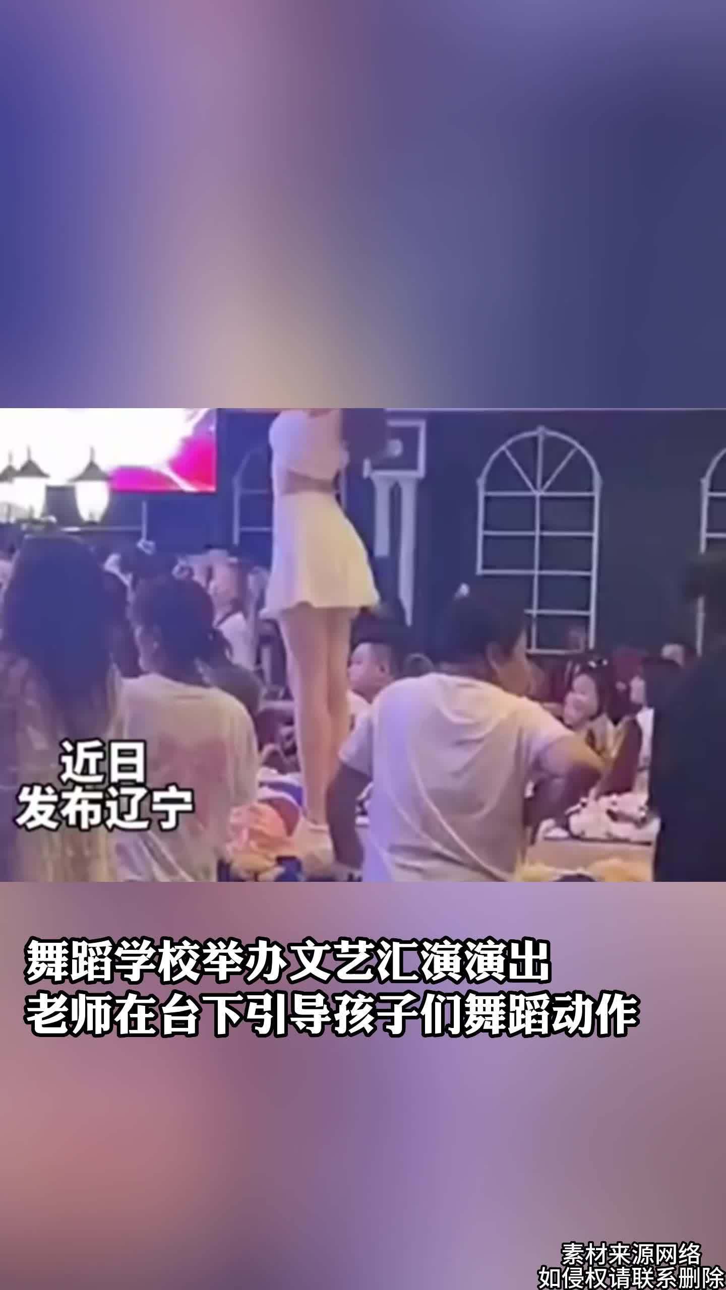 舞蹈学校举办文艺汇演演出,老师在台下引导孩子们舞蹈动作