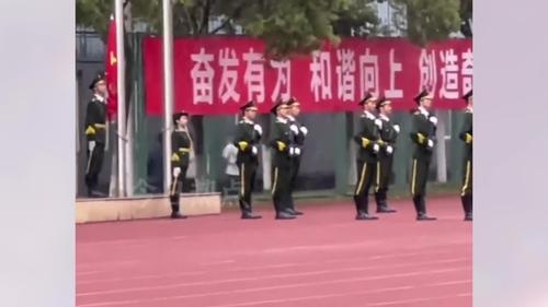 运动会还未开始便天降大雨,护旗队的同学仍昂首挺胸,寸步不动