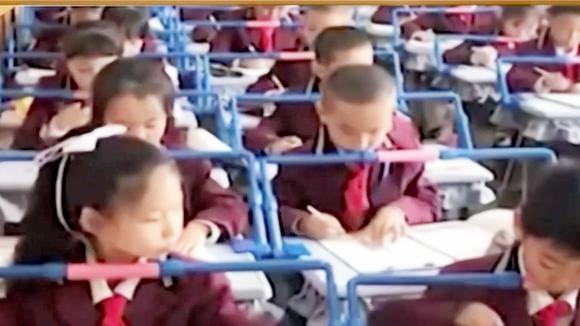 王多鱼的设计?小学课桌装书写矫正器防近视,趴下写字就被卡