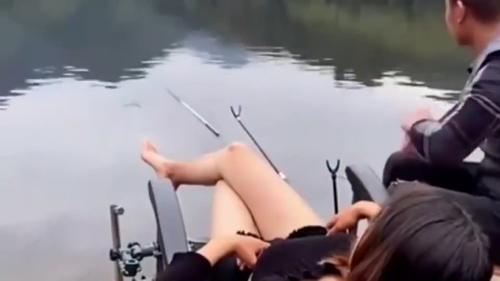 一看这大哥就不是资深钓鱼佬,美女坐旁边鱼竿都被拖走也不管了