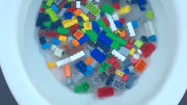 小伙把孩子的乐高积木倒入坐便器里,按冲水键会不会卡住?