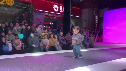 小男孩头次在台上走模特,步伐慢的就跟树懒一样,哪料竟直接停了下来!