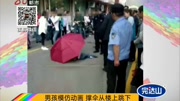 男孩模仿动画片 撑伞从楼上跳下