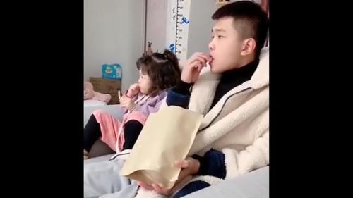 相差12岁的兄妹,看电视吃东西的动作一模一样