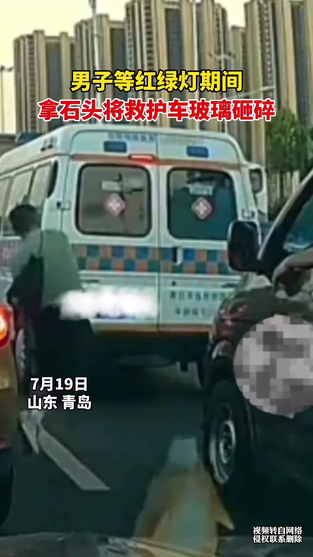男子拿石头将救护车玻璃砸。