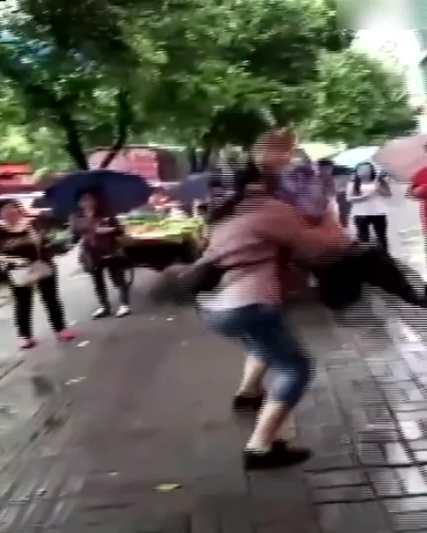 女摊贩与城管当街撕扯抱摔 动作似花式摔跤引围观