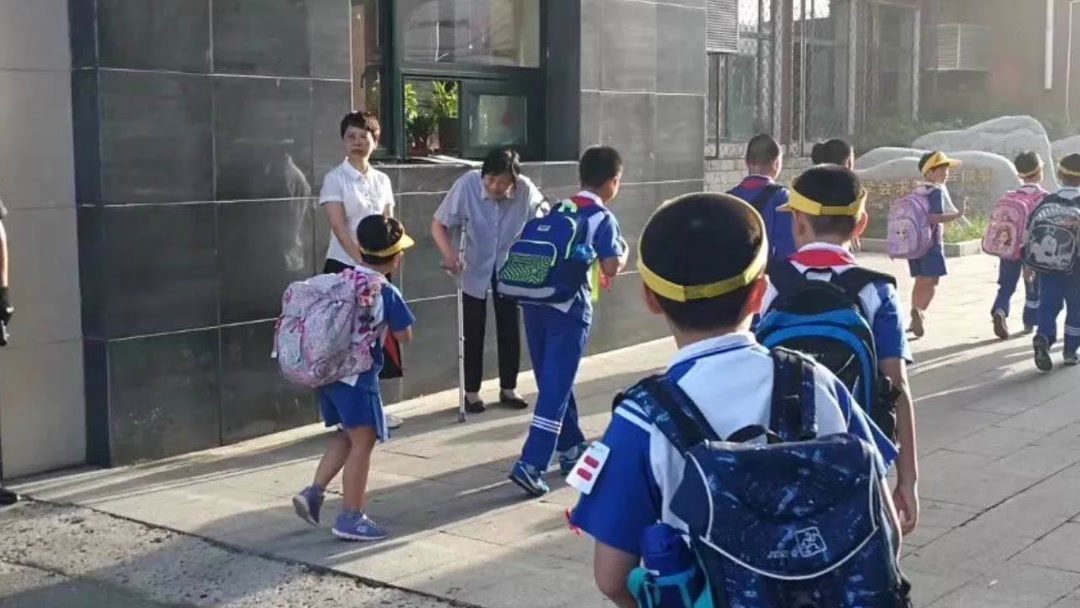 8旬老校长校门口拄拐鞠躬迎学生 网友:真正开学第一课