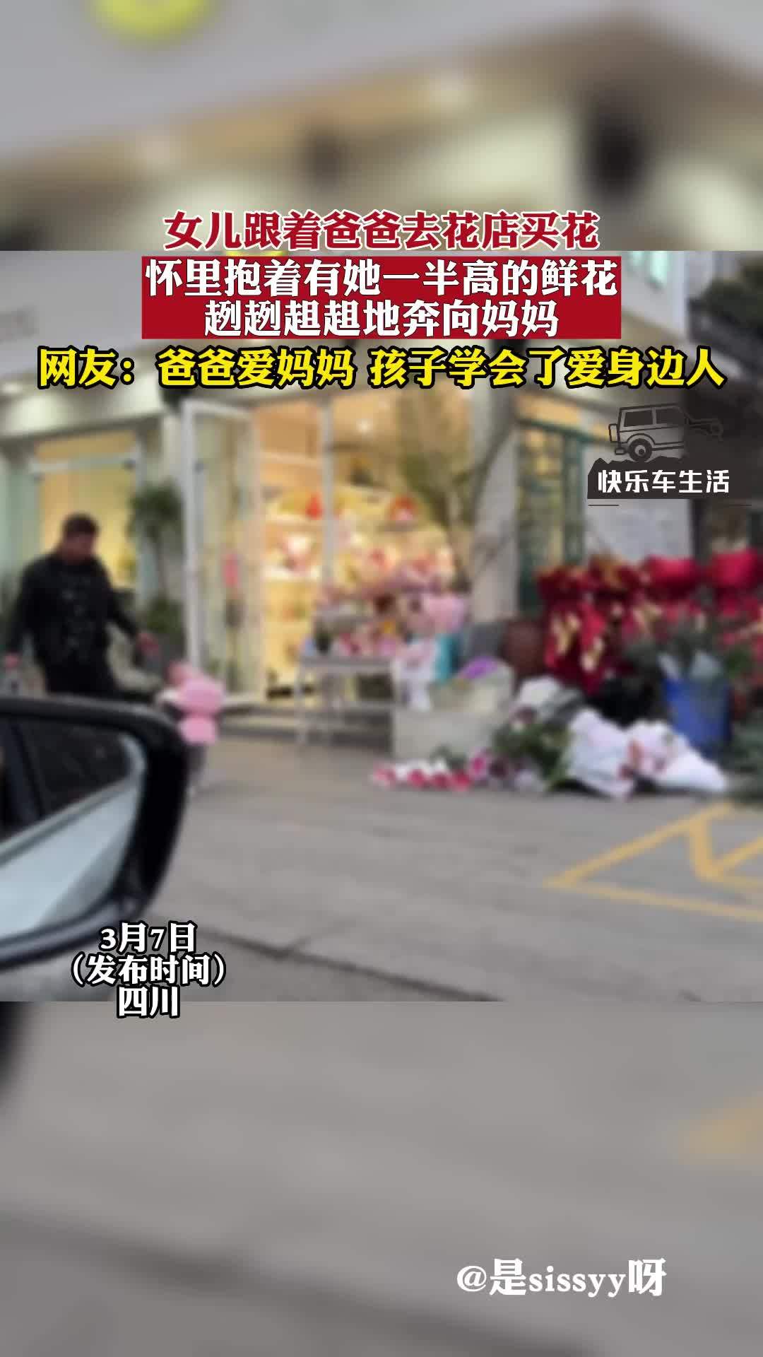 女儿跟着爸爸去花店买花,怀里抱着有她一半高的鲜花,趔趔趄趄地奔向.