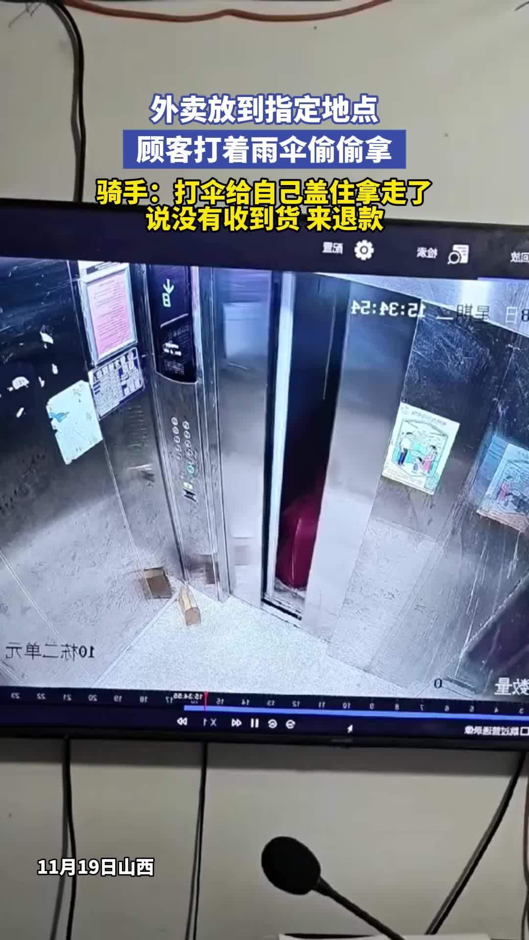 外卖放到指定地点后,顾客打着雨伞偷偷拿