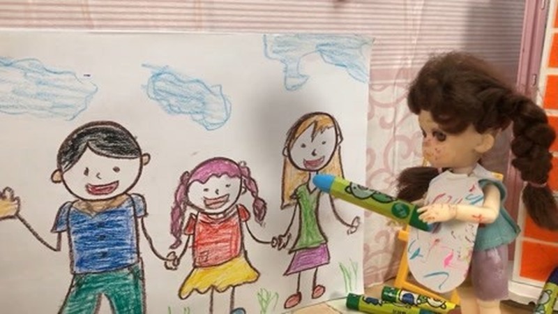 小芭比放假在家里画画,画上爸爸妈妈和她一家三口的全家福