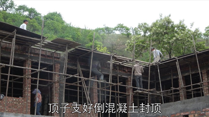 老师傅在房顶上支满钢管架,吊上去竹胶板面,开始绑钢筋网