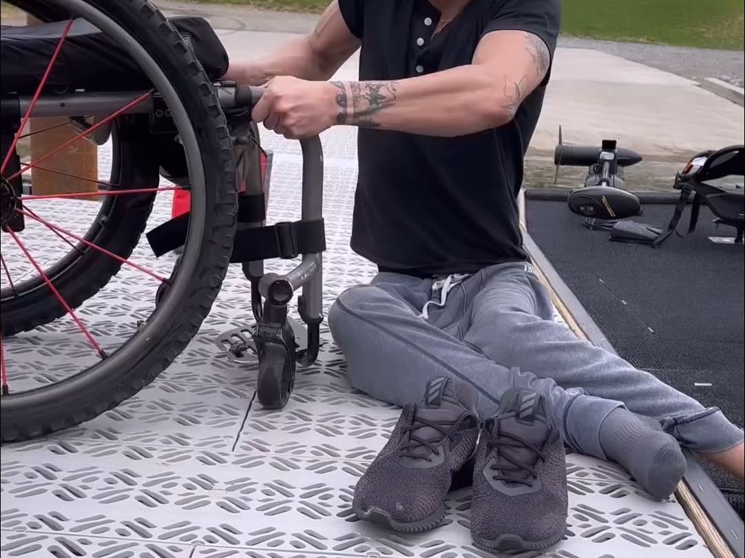 从船上爬上轮椅的灰袜小哥