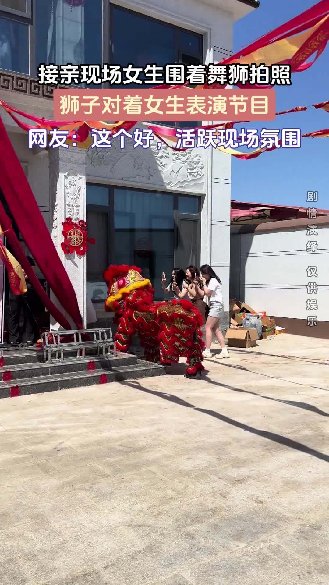接亲现场女生围着舞狮拍照,狮子对着女生表演节目。