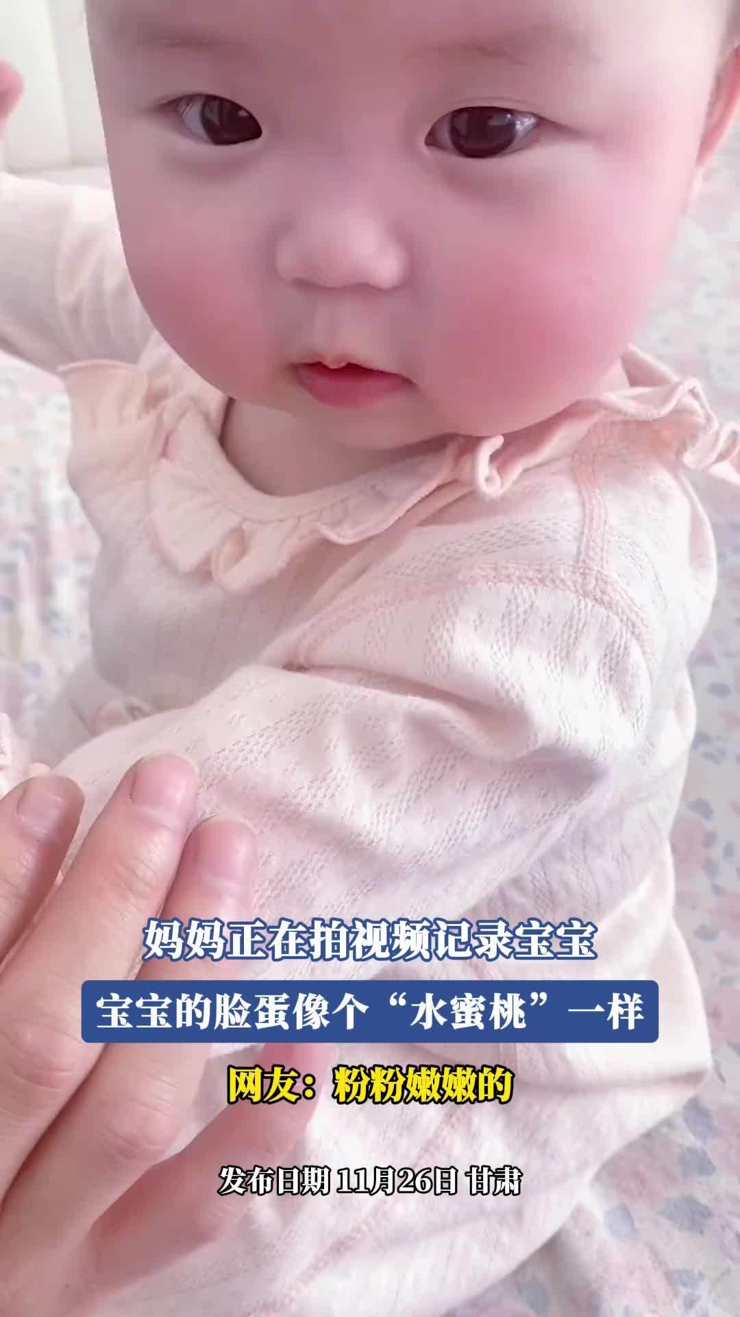 妈妈正在拍视频记录宝宝,宝宝的脸蛋像个"水蜜桃"一样