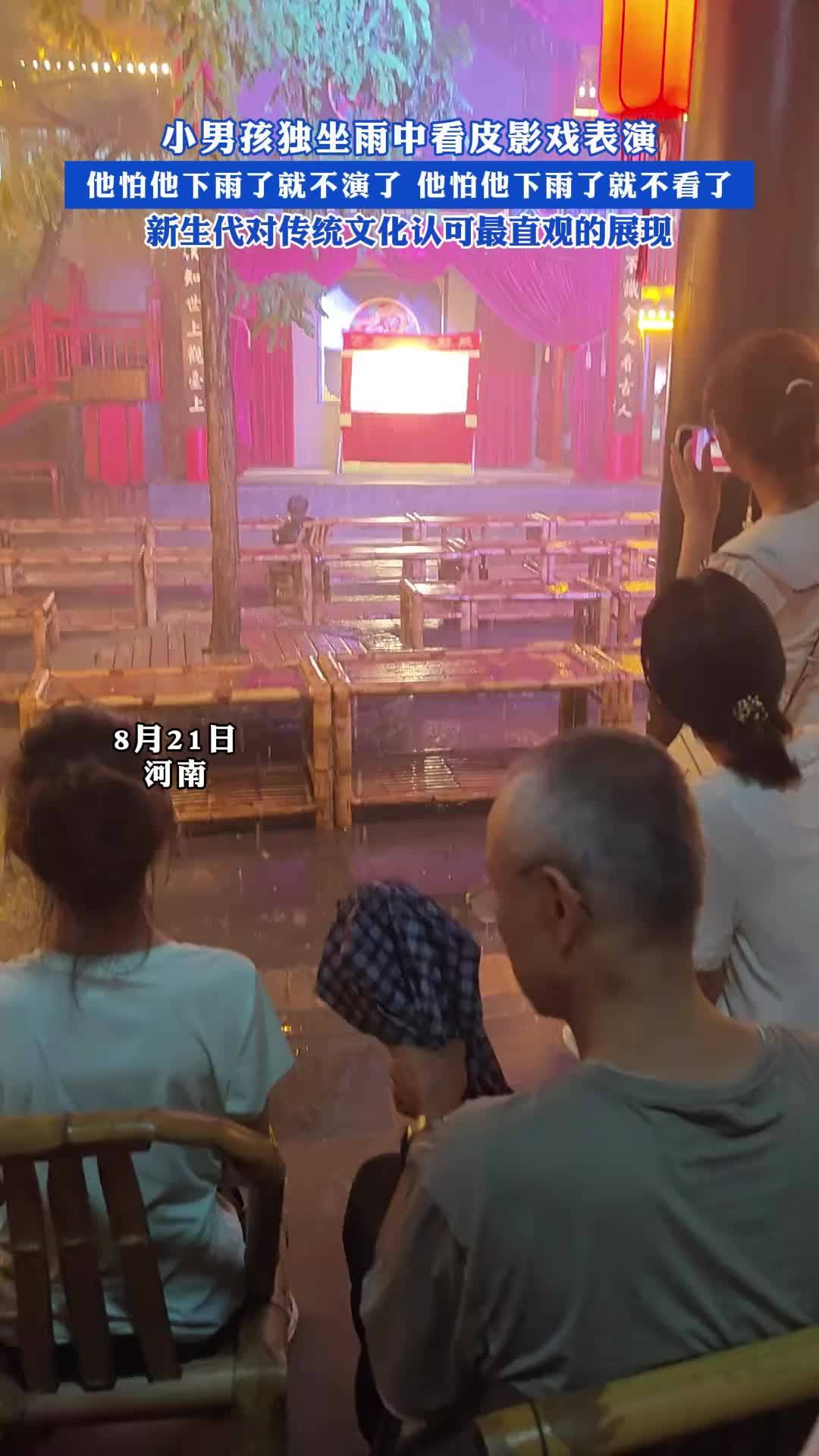 小男孩独坐雨中看皮影戏表演