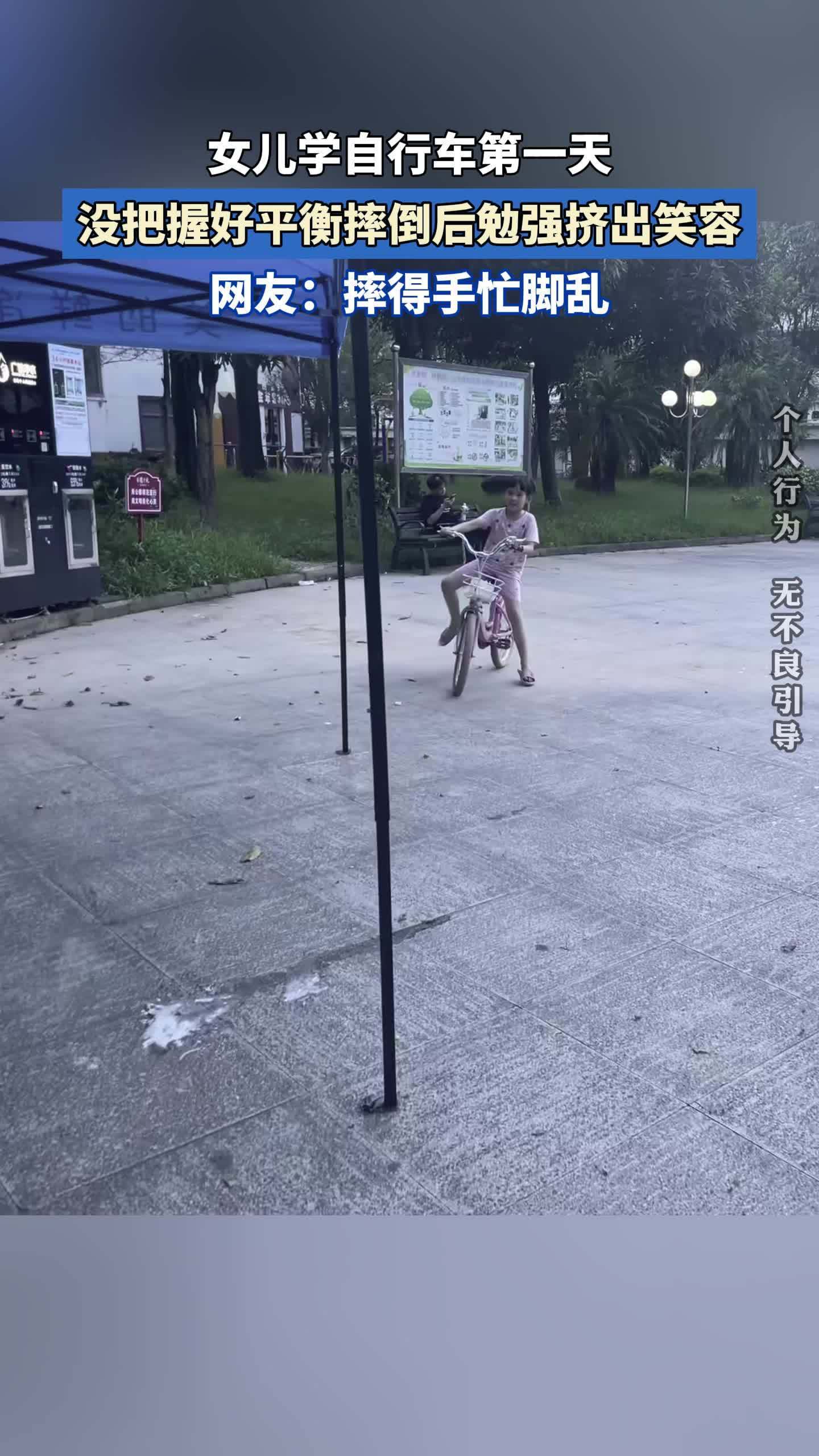 女儿学自行车第一天,没把握好平衡摔倒后勉强挤出笑容。