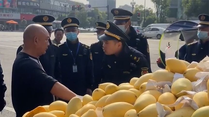 商贩非法摆摊经营,被城管扣货,城管耐心向商贩解释