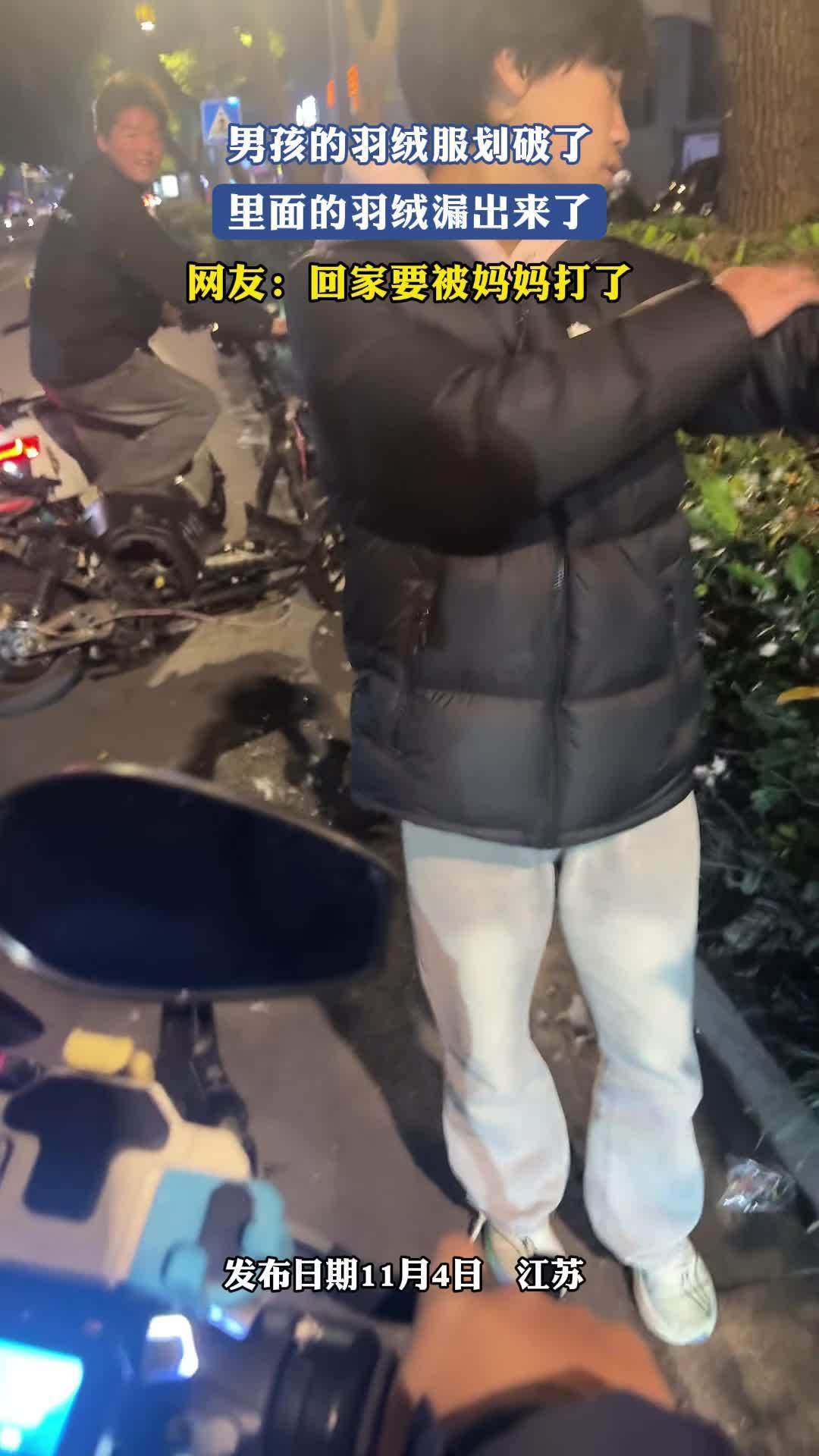 男孩的羽绒服划破了,里面的羽绒漏出来了,回家要被妈妈打了