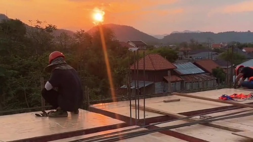 在落日的余晖中,工人们正在安装模板