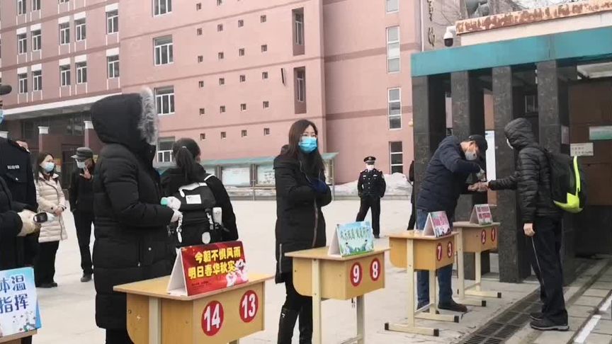 高三复课首日 ,测温后戴着口罩的学生走进校园,课桌间隔一米