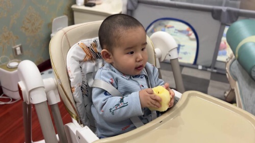 11月龄的小宝宝一边快乐啃苹果,一边学会了如何吞咽与咀嚼