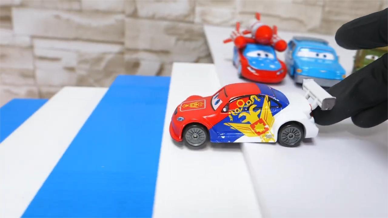 小男孩喜欢的赛车总动员玩具车和小伙伴们在阶梯上滑行进入水池