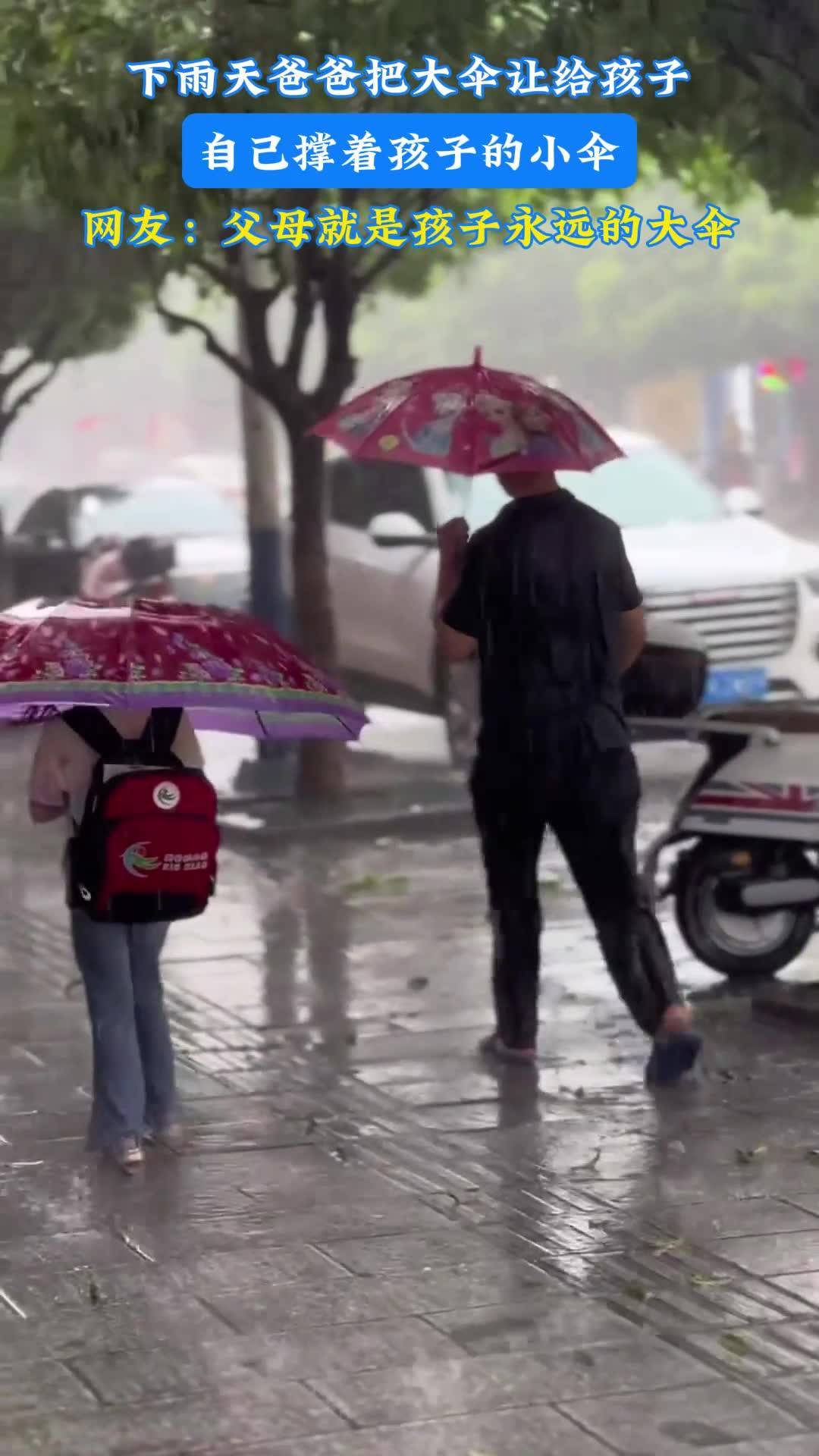 下雨天爸爸把大伞让给孩子,自己撑着孩子的小伞