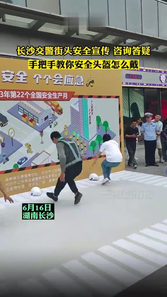 长沙交警街头安全宣传,手把手教会戴头盔。