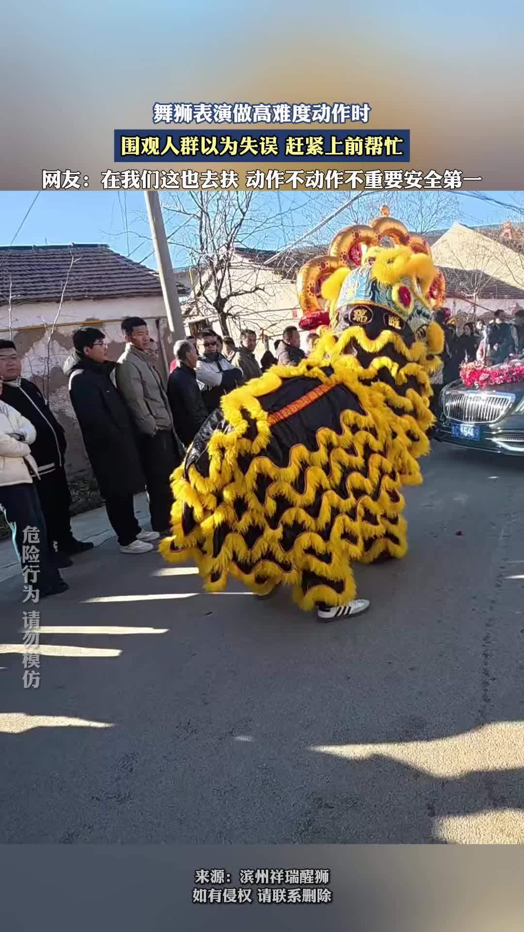 舞狮表演做高难度动作时,围观人群以为失误赶紧上前帮忙。