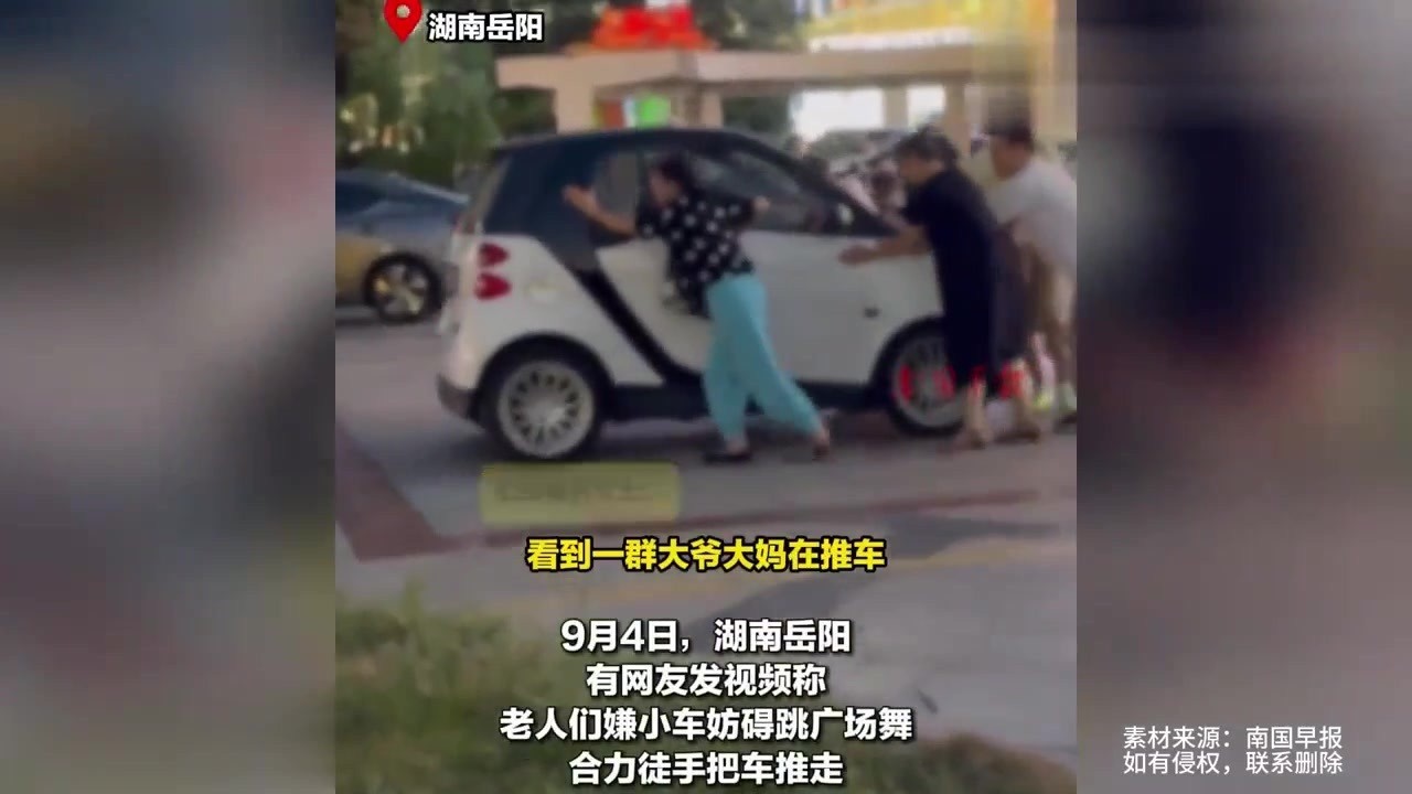 嫌小车妨碍跳广场舞?众人合力徒手推车