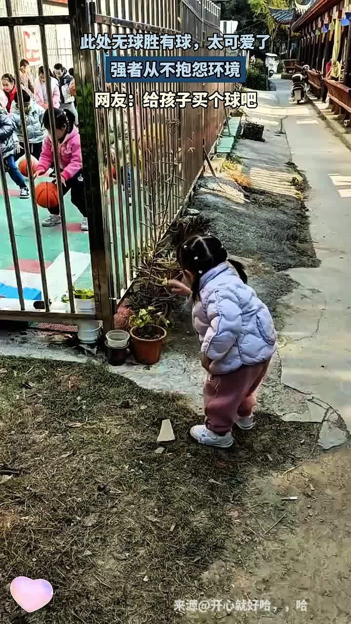 小女孩站在学校门口,模仿小朋友的姿势,练习拍球动作