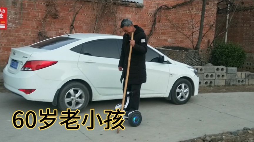 洛阳山村60岁老小孩拄拐杖学骑平衡车,孙子在一边指导