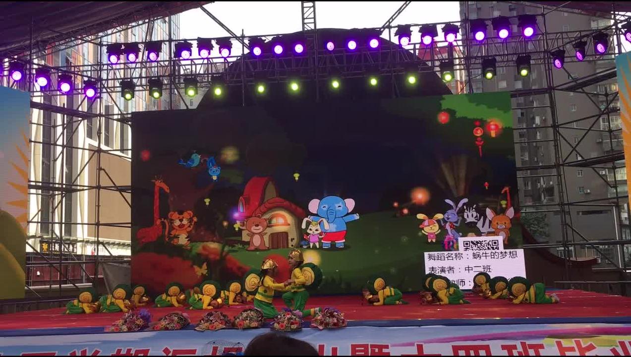 孩子们的毕业晚会,快要结束还下着雨,家长们都打着伞陪着孩子们演出...