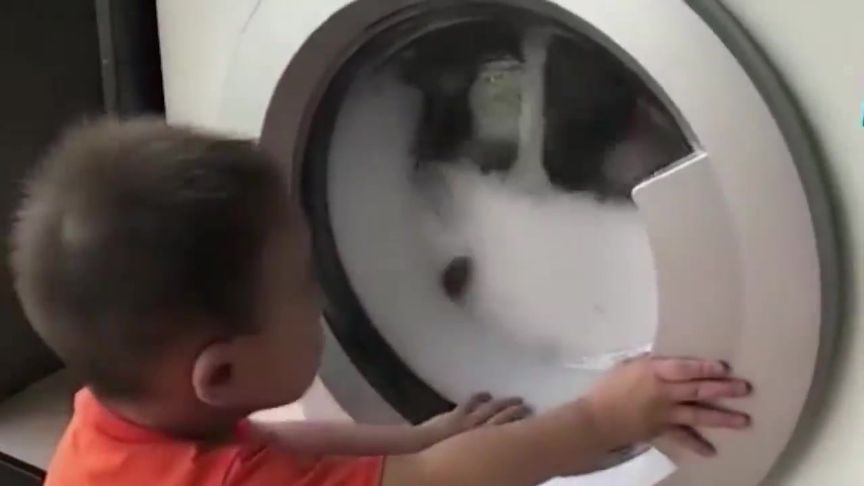 妈妈把宝宝的被子洗了,宝宝坐在洗衣机旁边看着,真可爱!