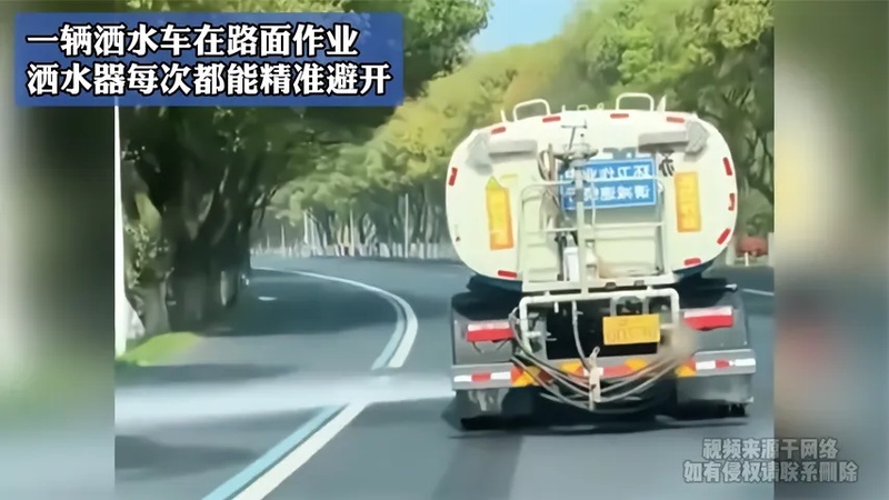 一辆洒水车在路面作业,洒水器每次都能精准避开
