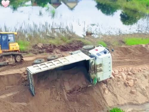 渣土车司机失误翻车 挖机和推土机一起救援