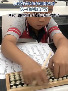 小孩拔弄算盘看似随便乱拨,却一脸专注的模样