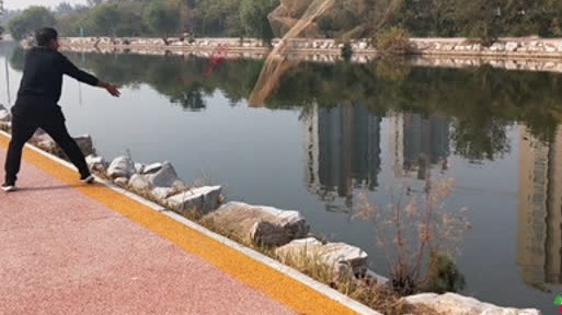 清晨,小伙野河边示范二把网撒网.