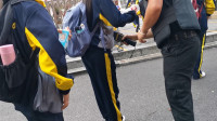 学校保安用金属探测仪查手机刀具,学生校门口排长队等待安检