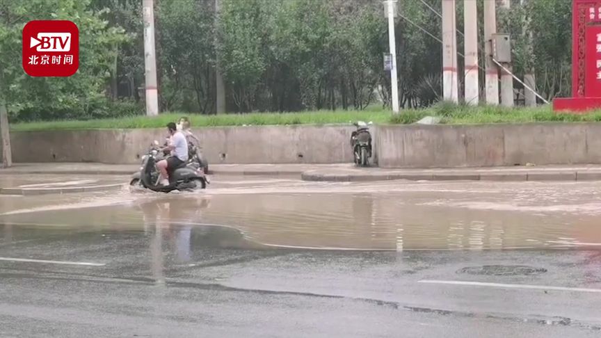 贴心!公交站台雨后积水困乘客 公交司机骑电动车做起“摆渡人”