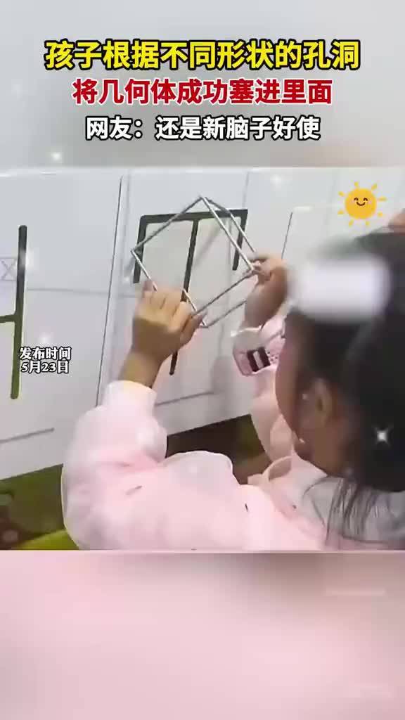 孩子根据不同形状的孔洞,将几何体成功塞进里面