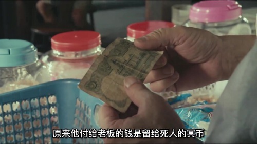 男孩拿着冥币到小卖部买零食