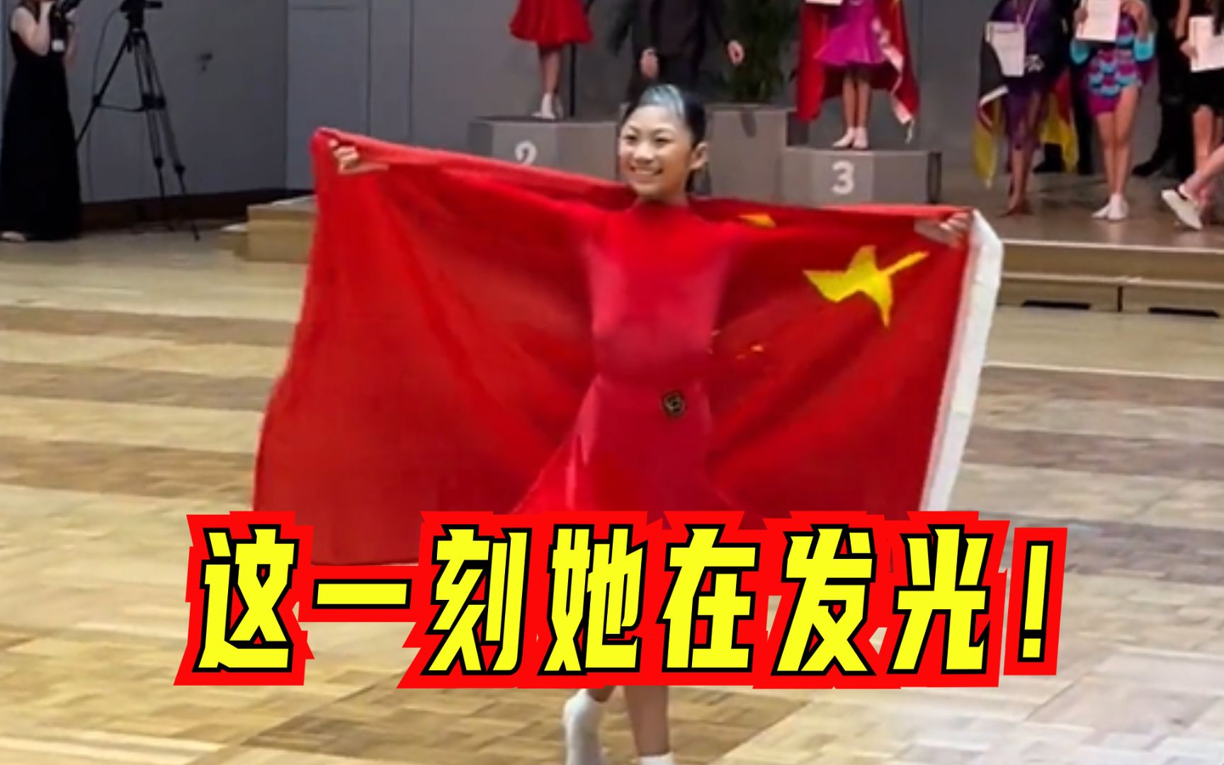中国女孩在国际舞蹈比赛中夺冠后,身披五星红旗优雅登上领奖台